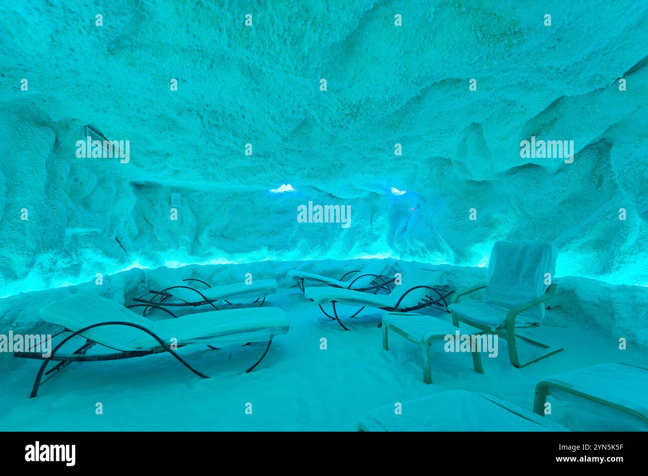 Illuminated salt cave interior with lounge chairs and therapeutic ...