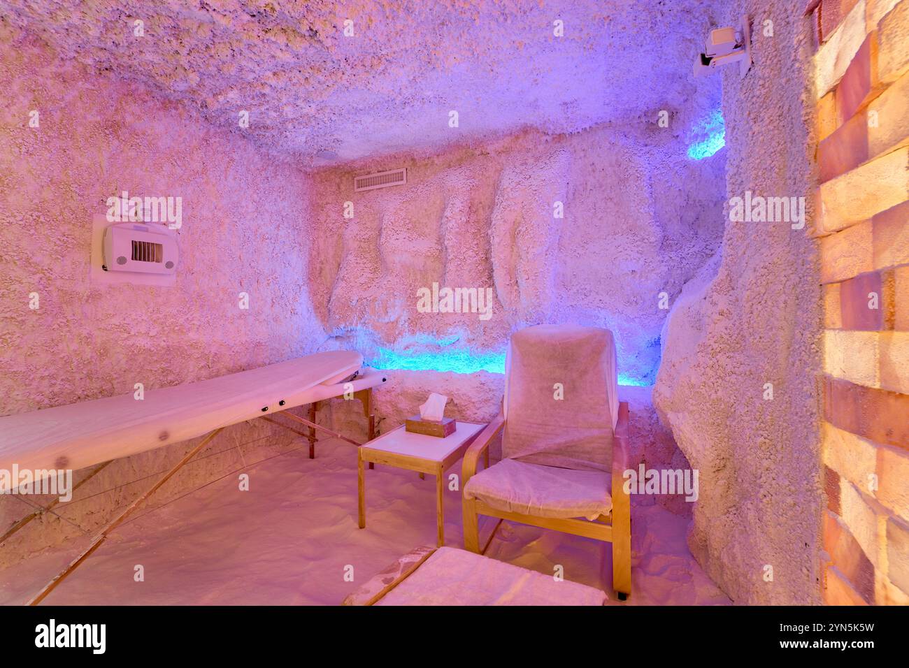 Salt therapy room with massage table and chairs in a relaxing ambiance ...