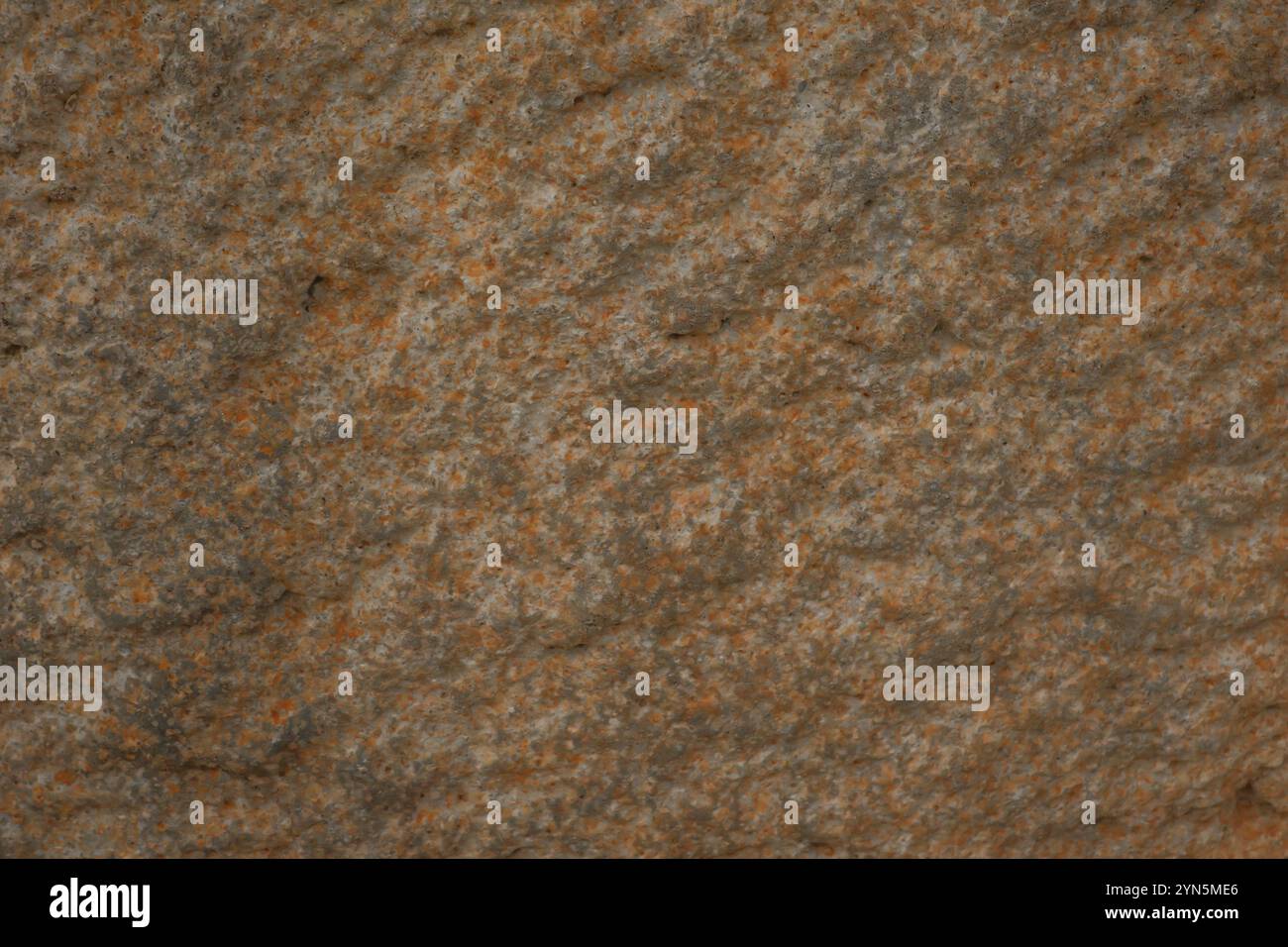 Close-up of a natural stone texture with earthy tones of orange and ...