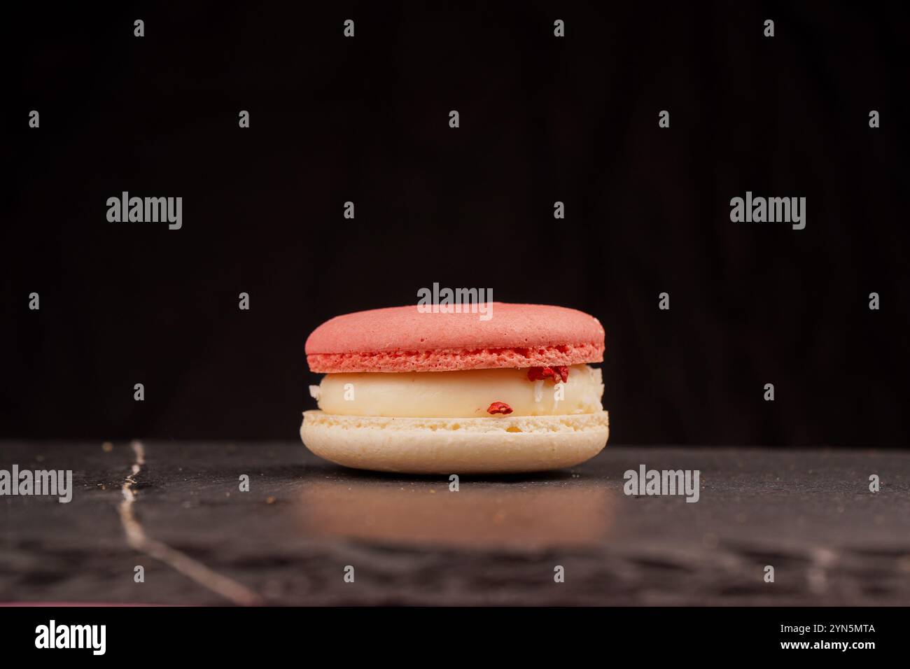 A close-up view of peach-hued macarons highlighting their chewy texture ...