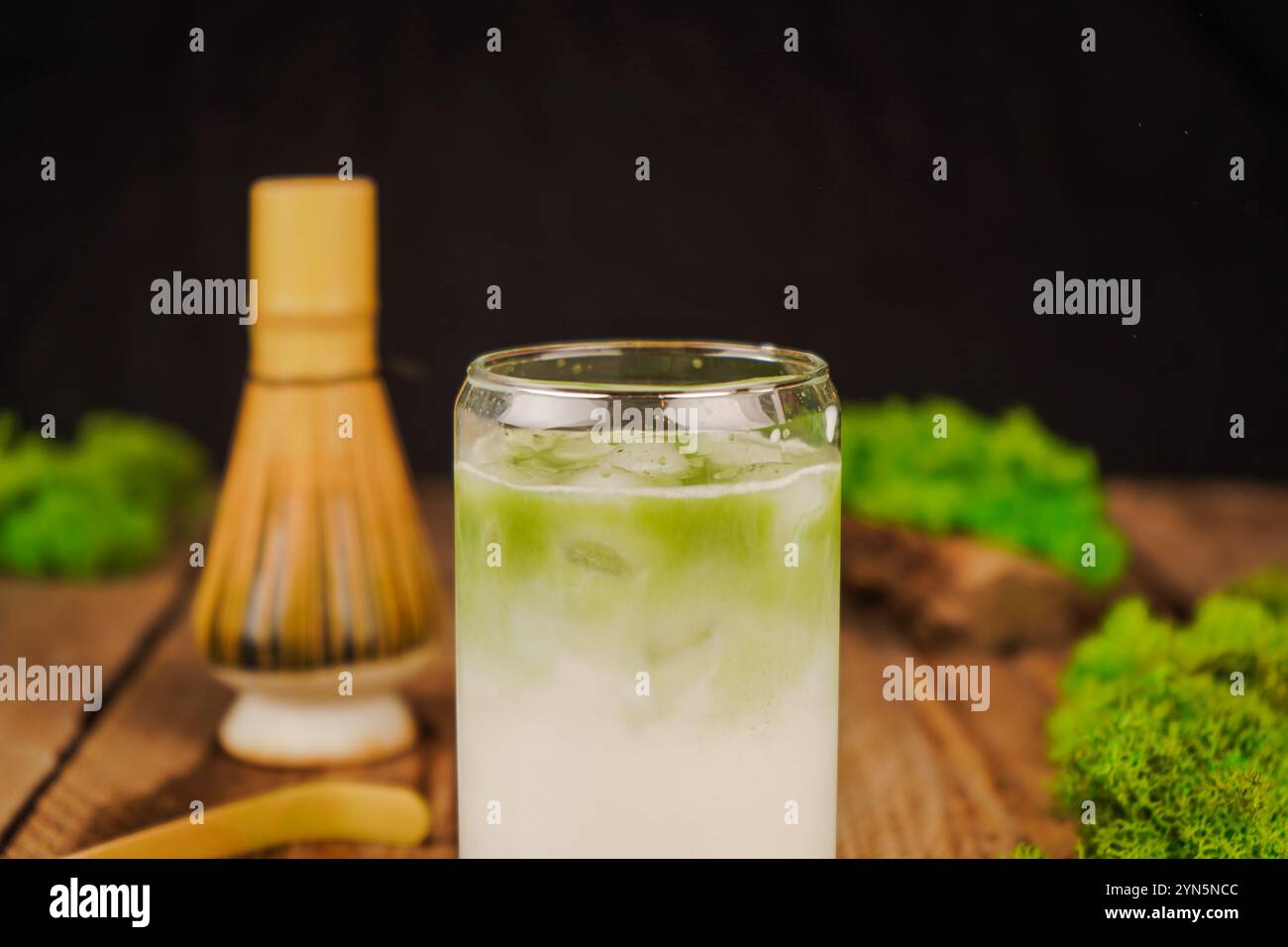 A close-up shot of a bamboo matcha whisk resting on a matcha table ...