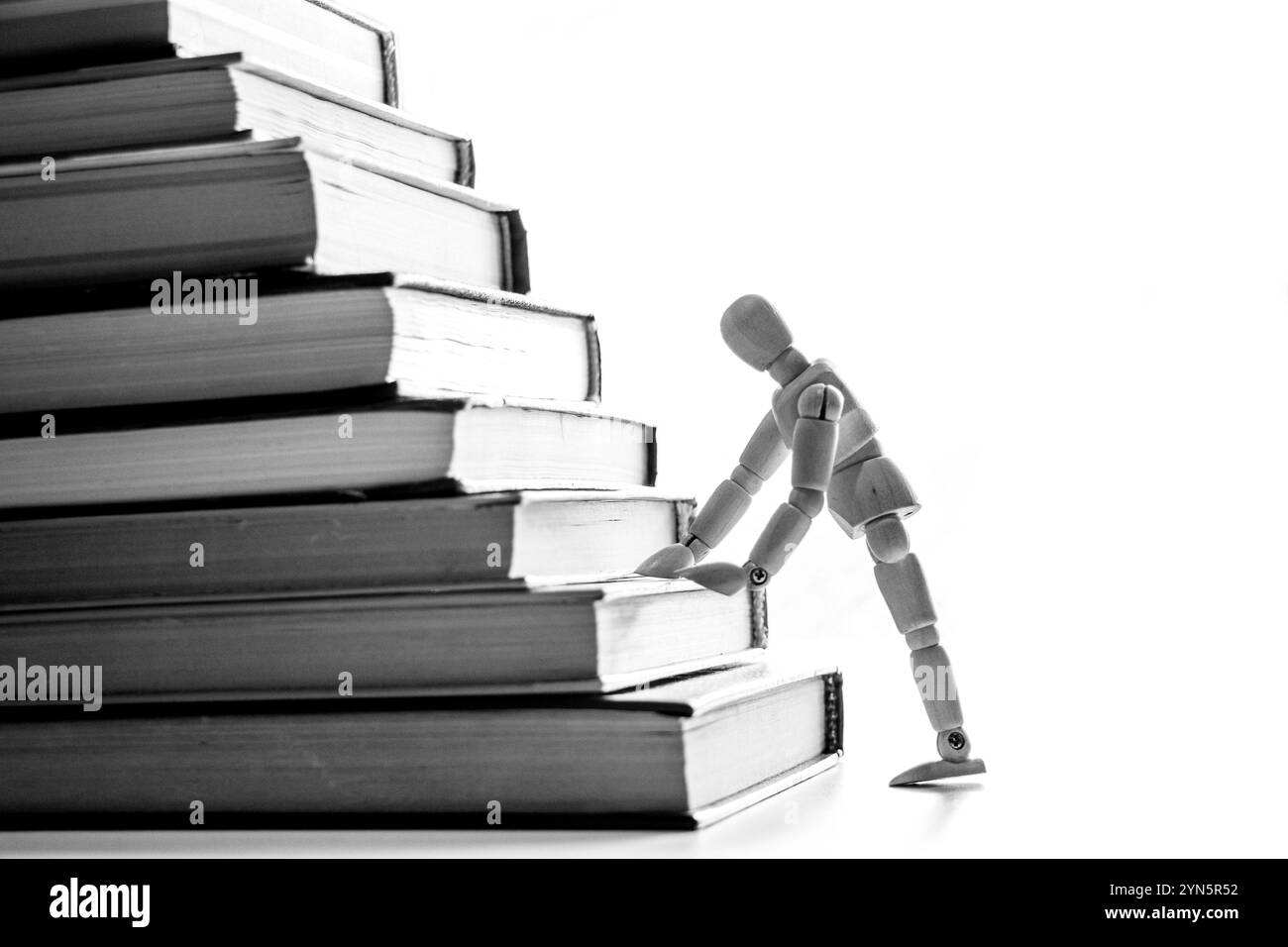 Wooden one-legged man and books as steps up, overcoming obstacles ...