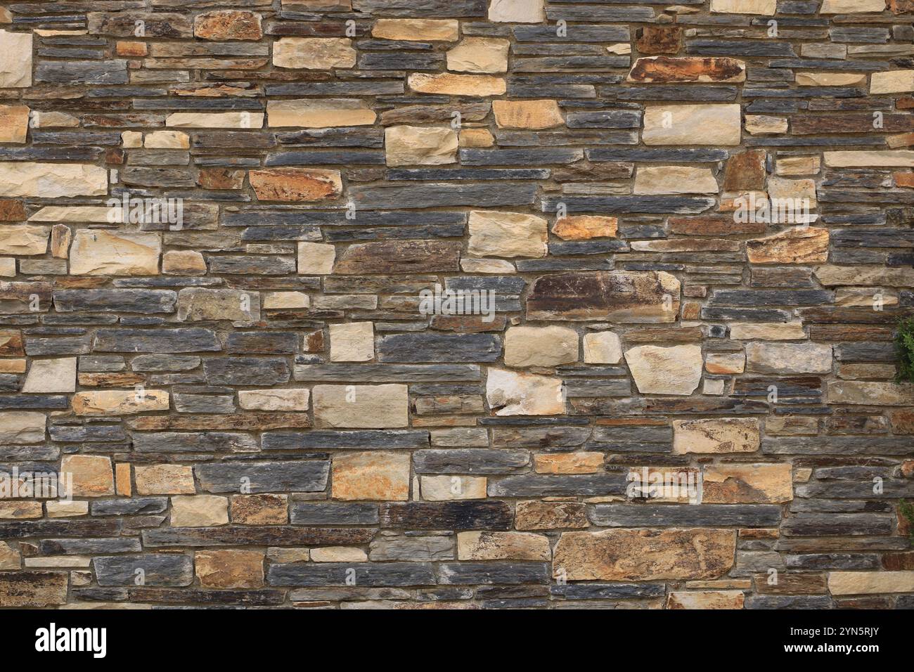 a Stacked stone brick wall. Stone cladding wall made of natural grey ...