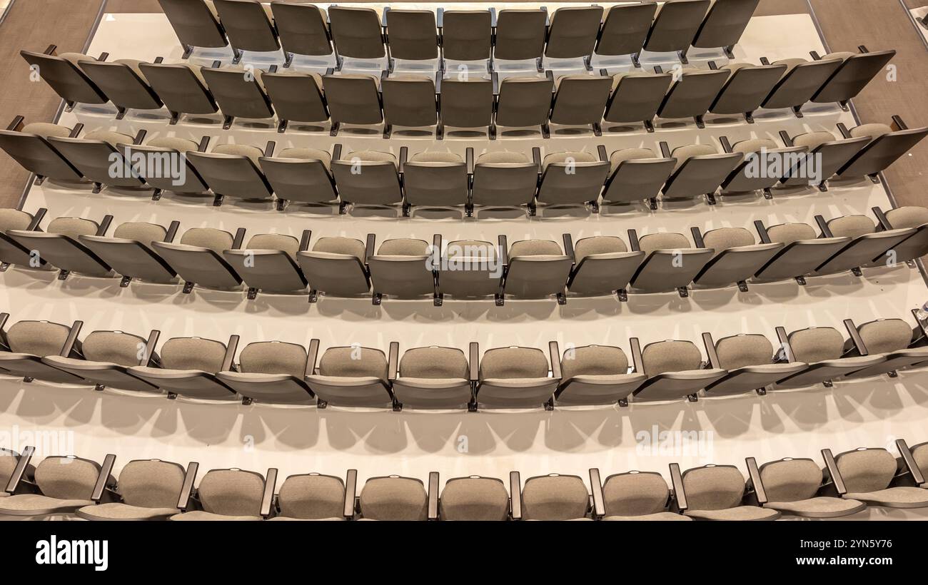 Overhead image of empty tan / gray theater, auditorium seats, chairs ...