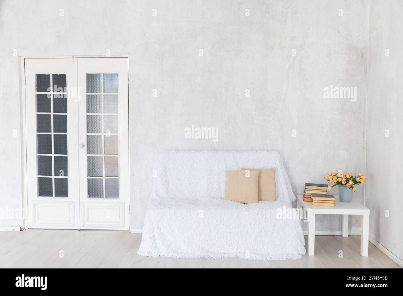 sofa and book reading table in the interior of a room with a door Stock ...