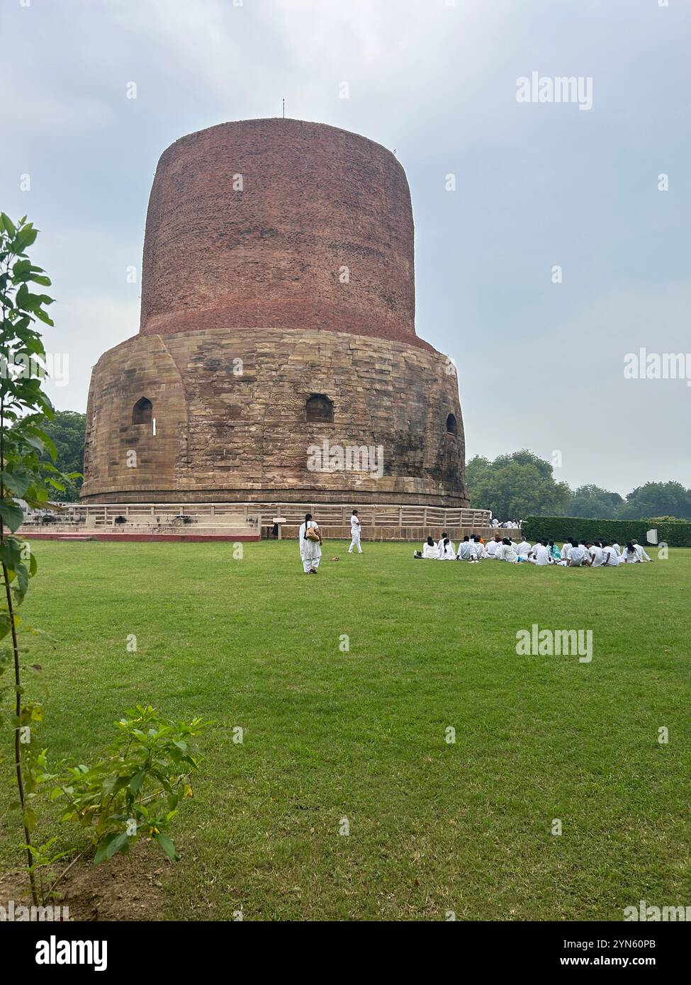 Buddhist students dressed in white, being taught on field outside ...