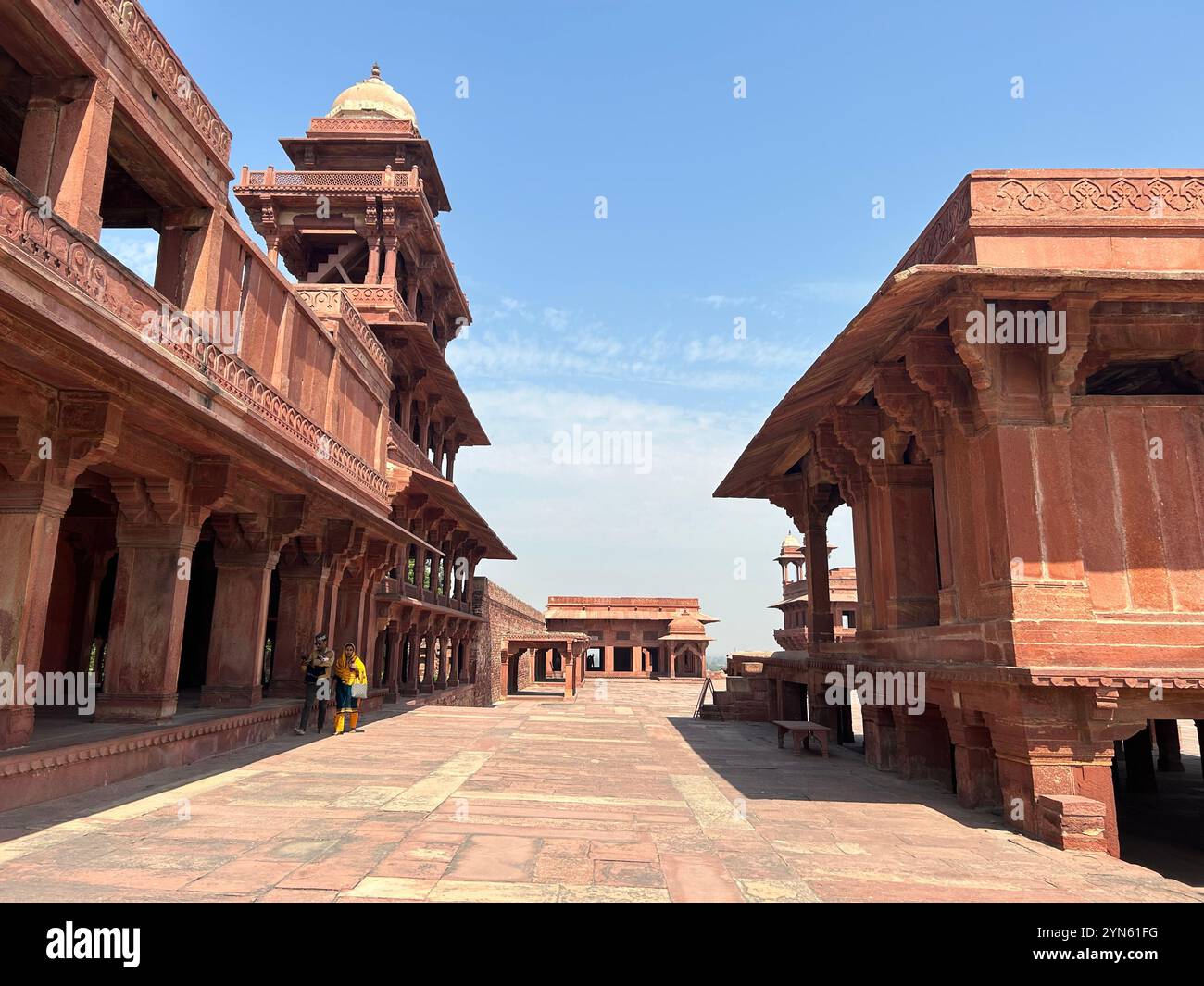 Indian officer and wife walking through red sandstone monuments at ...