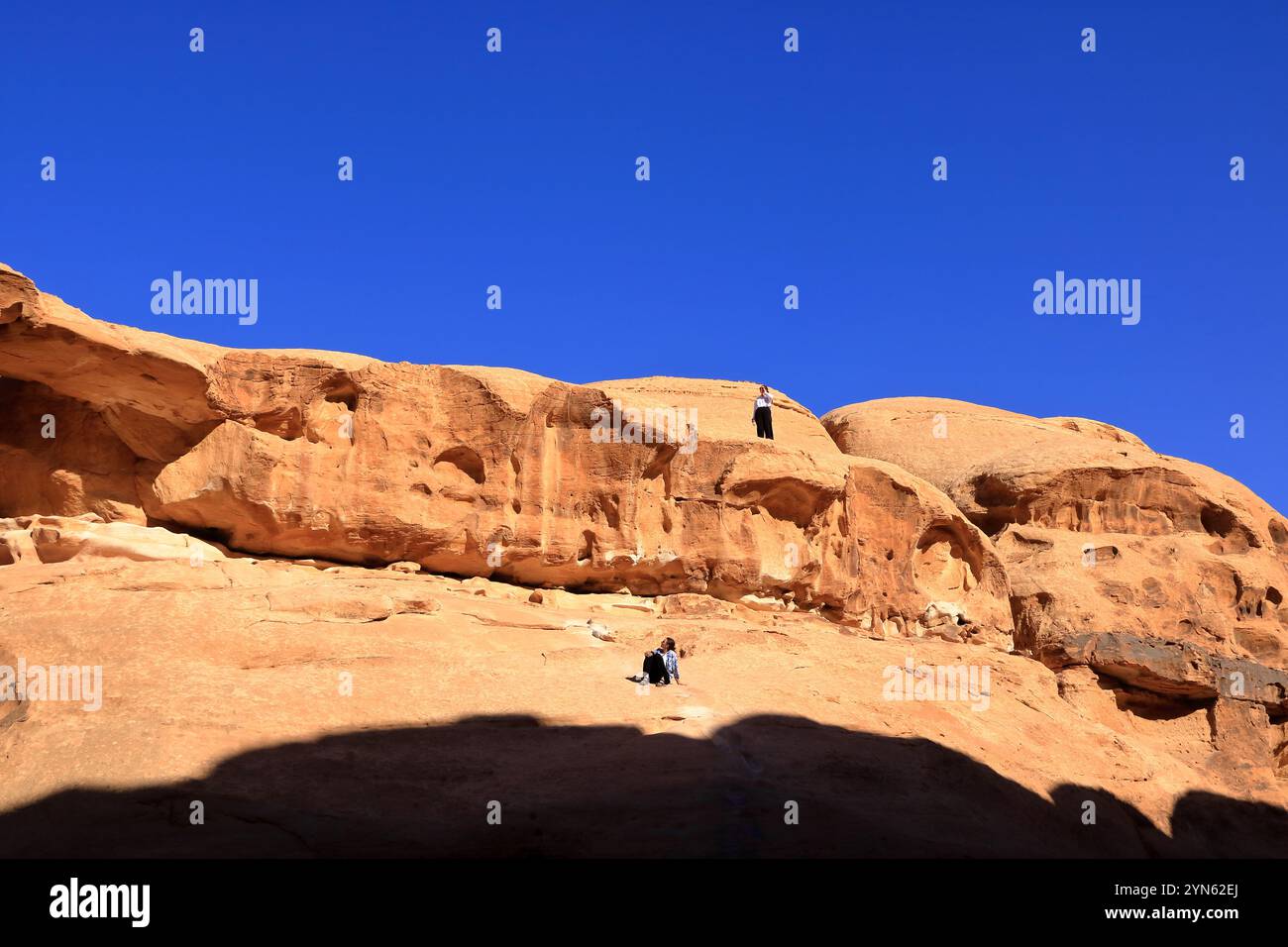 Wadi Rum in Jordan - May 15 2024: people climb up the Jebel Burdah rock ...