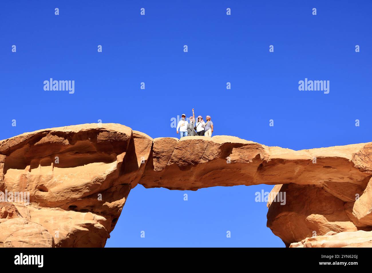 Wadi Rum in Jordan - May 15 2024: people climb up the Jebel Burdah rock ...