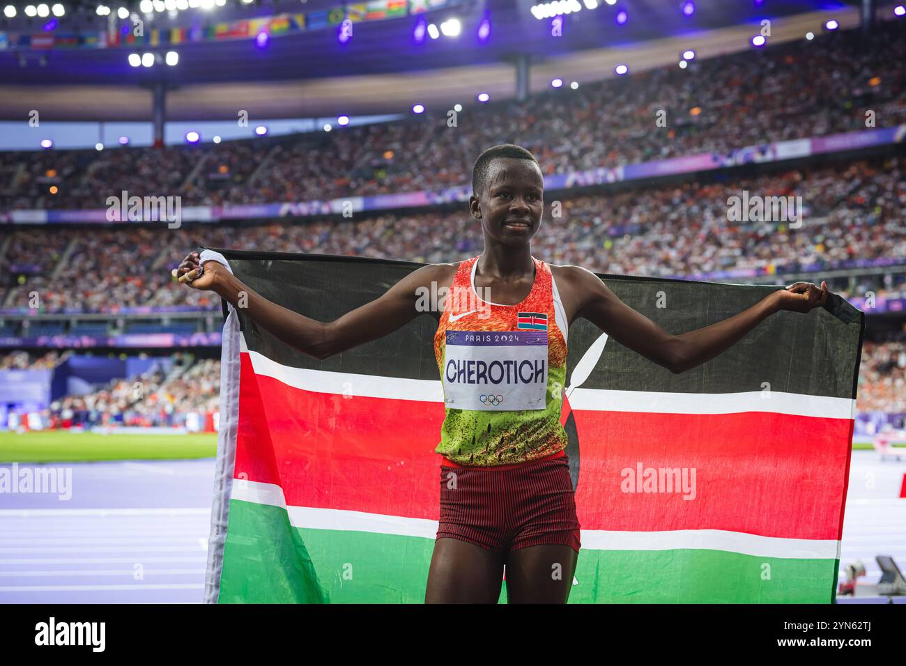Faith Cherotich celebrating her medal with her country's flag at the ...