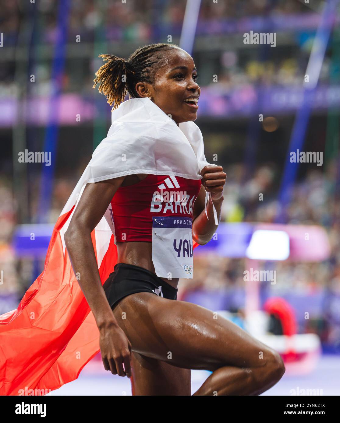 Winfred Yavi celebrating her medal with her country's flag at the Paris ...