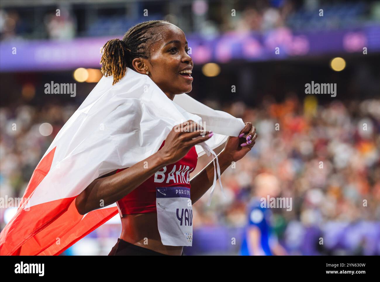 Winfred Yavi celebrating her medal with her country's flag at the Paris ...
