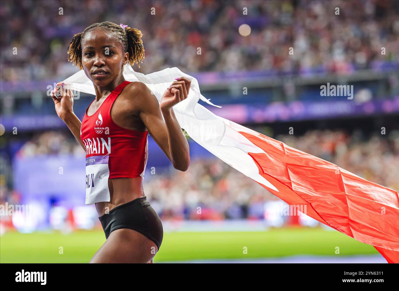 Winfred Yavi celebrating her medal with her country's flag at the Paris ...