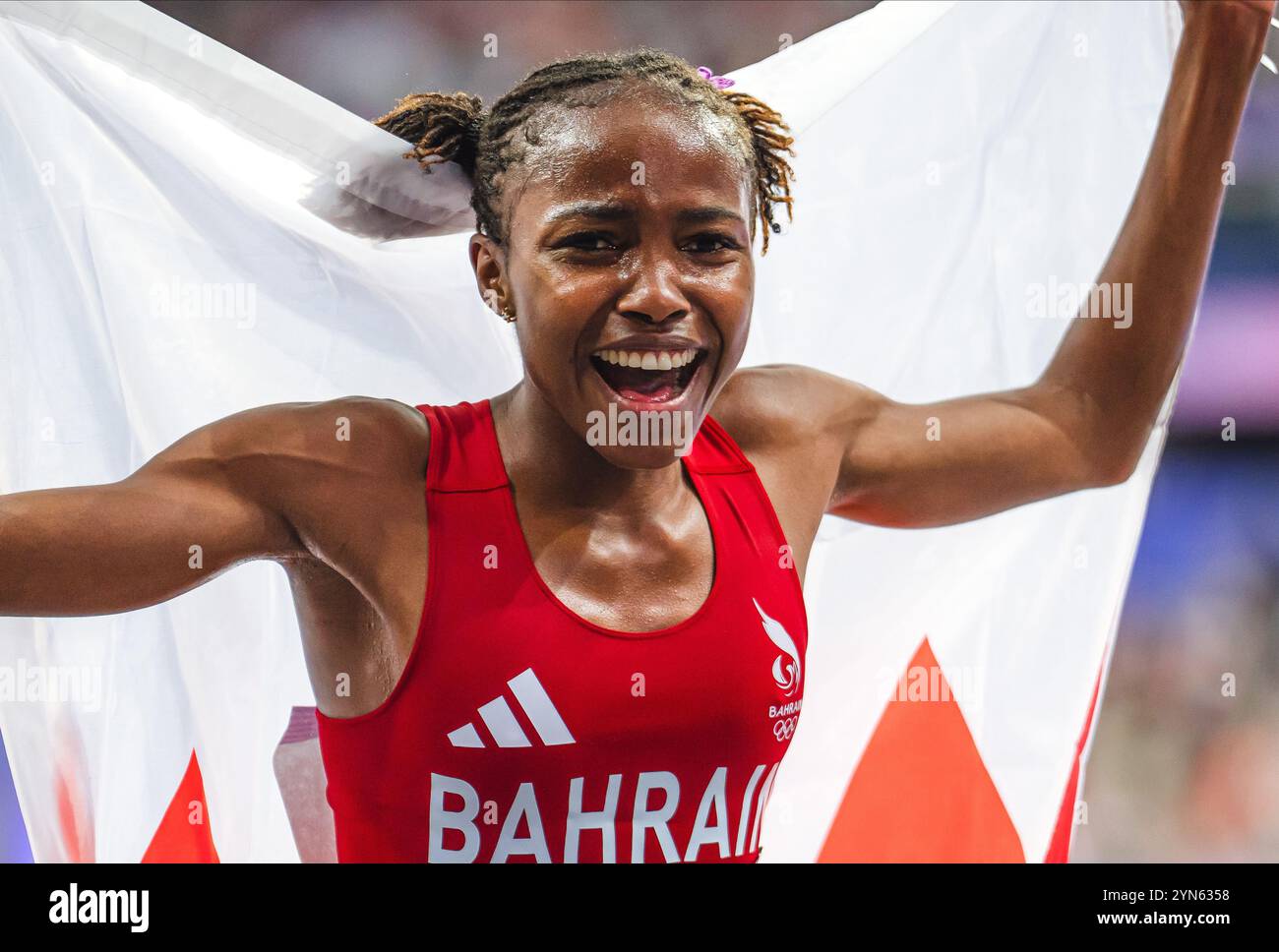 Winfred Yavi celebrating her medal with her country's flag at the Paris ...