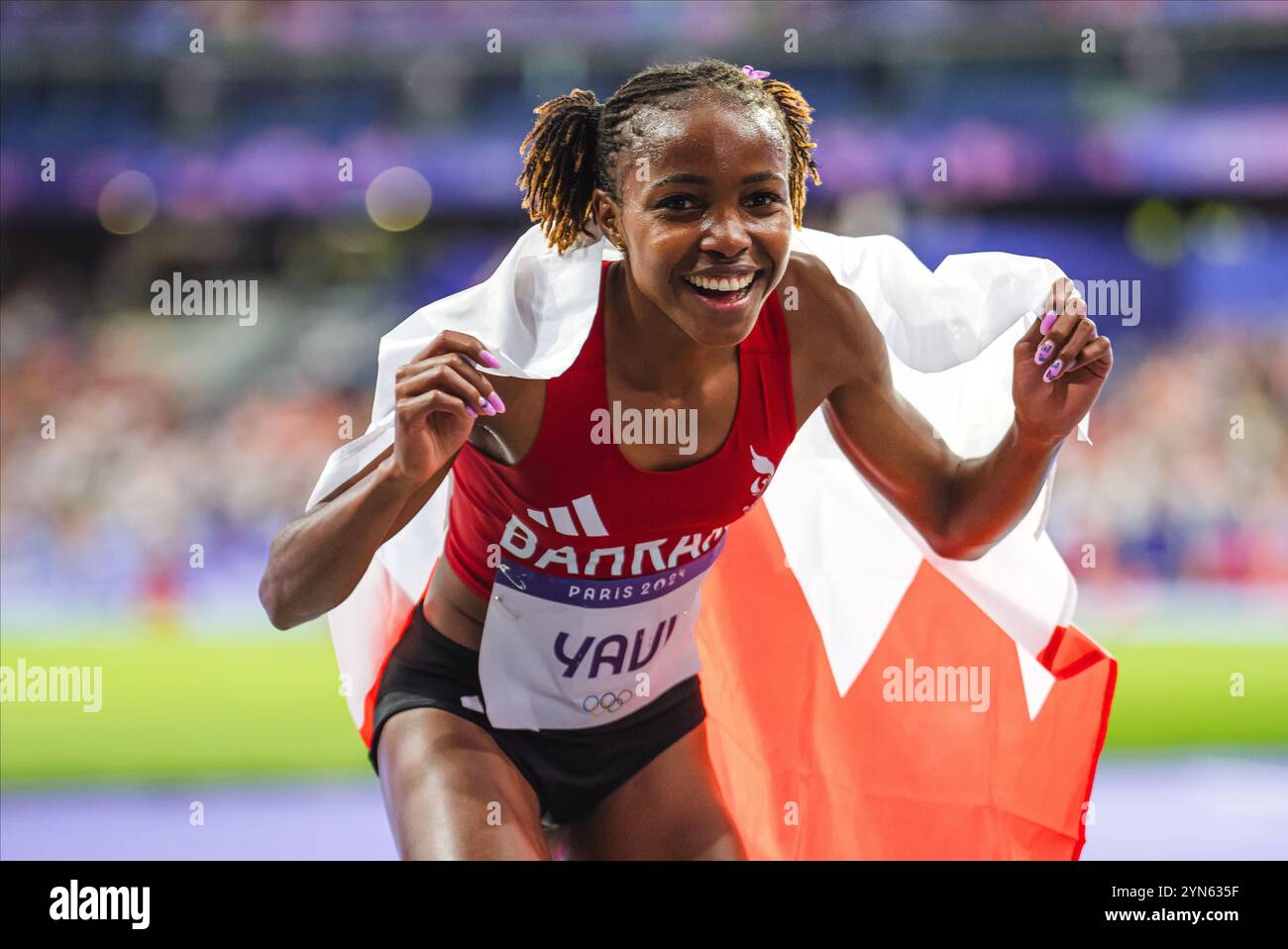 Winfred Yavi celebrating her medal with her country's flag at the Paris ...