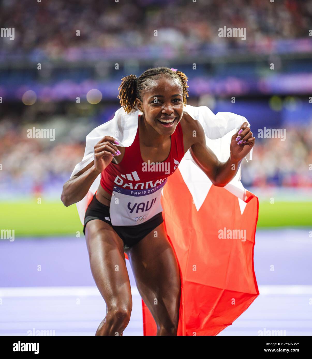 Winfred Yavi celebrating her medal with her country's flag at the Paris ...