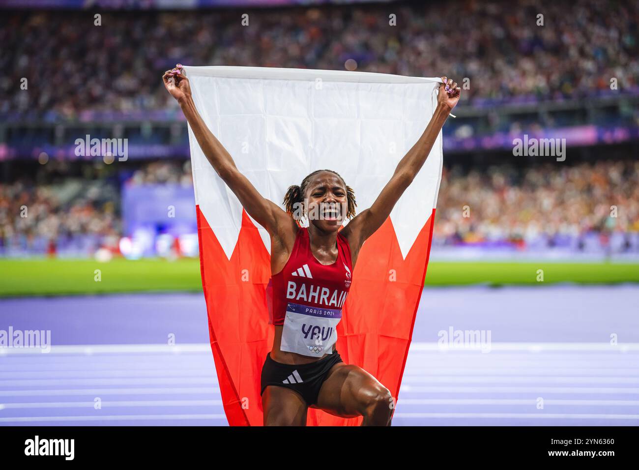 Winfred Yavi celebrating her medal with her country's flag at the Paris ...