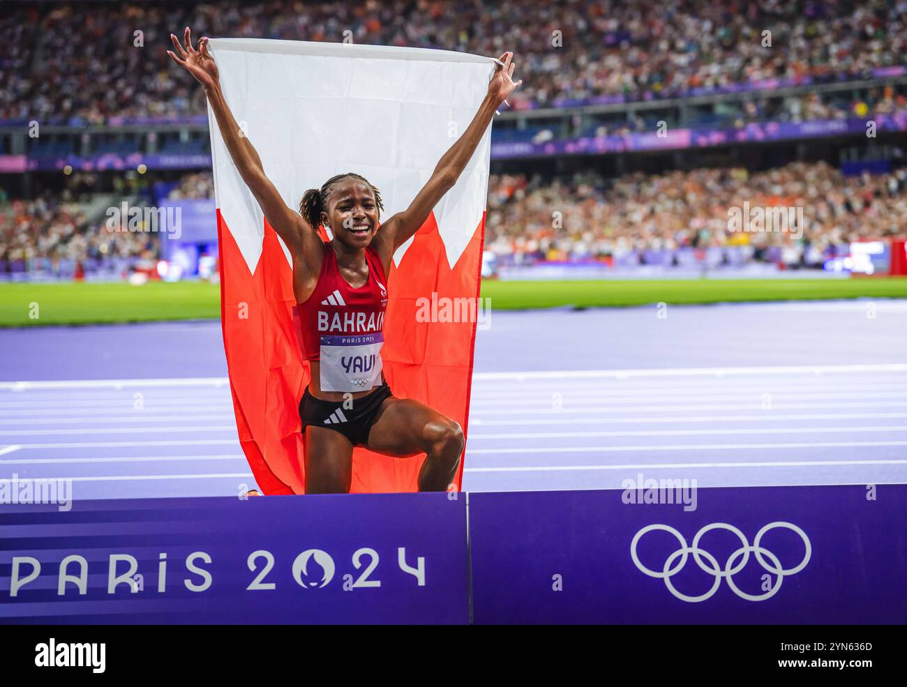 Winfred Yavi celebrating her medal with her country's flag at the Paris ...