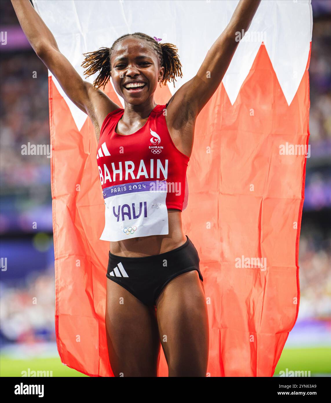 Winfred Yavi celebrating her medal with her country's flag at the Paris ...