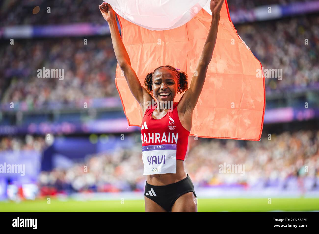 Winfred Yavi celebrating her medal with her country's flag at the Paris ...