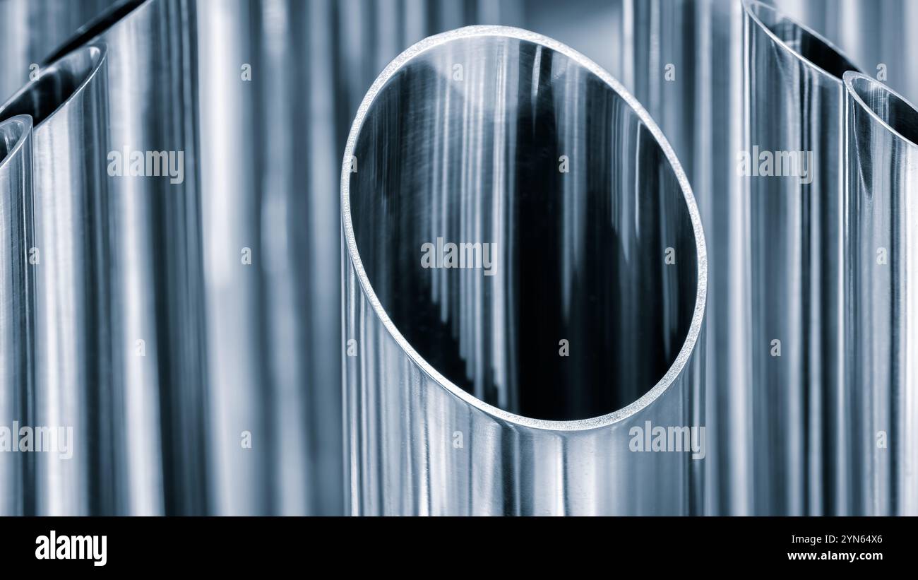 A row of metal pipes are shown in a close up. The pipes are silver and ...