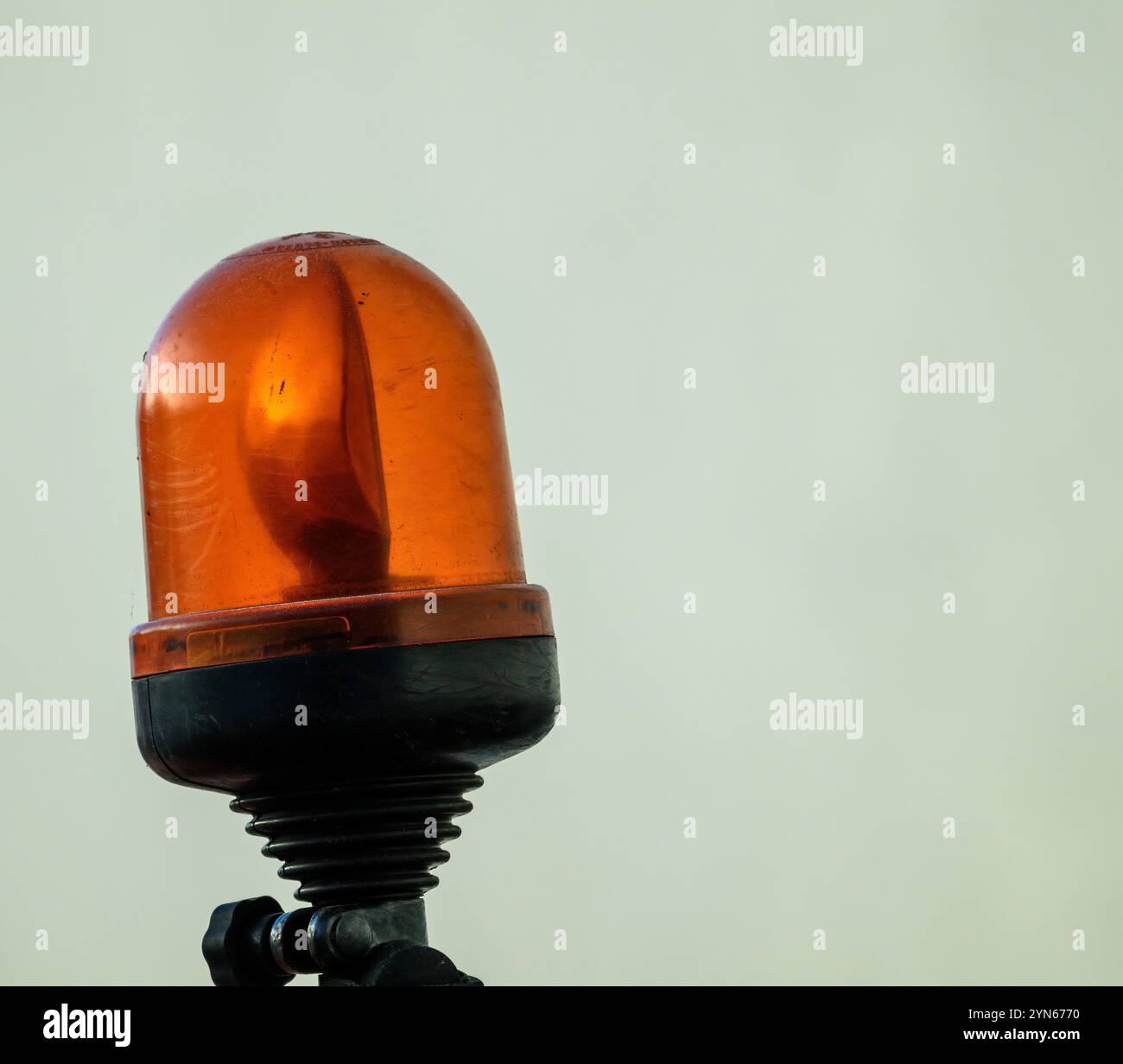 An orange rotating signal light is mounted on a sturdy base. The light ...