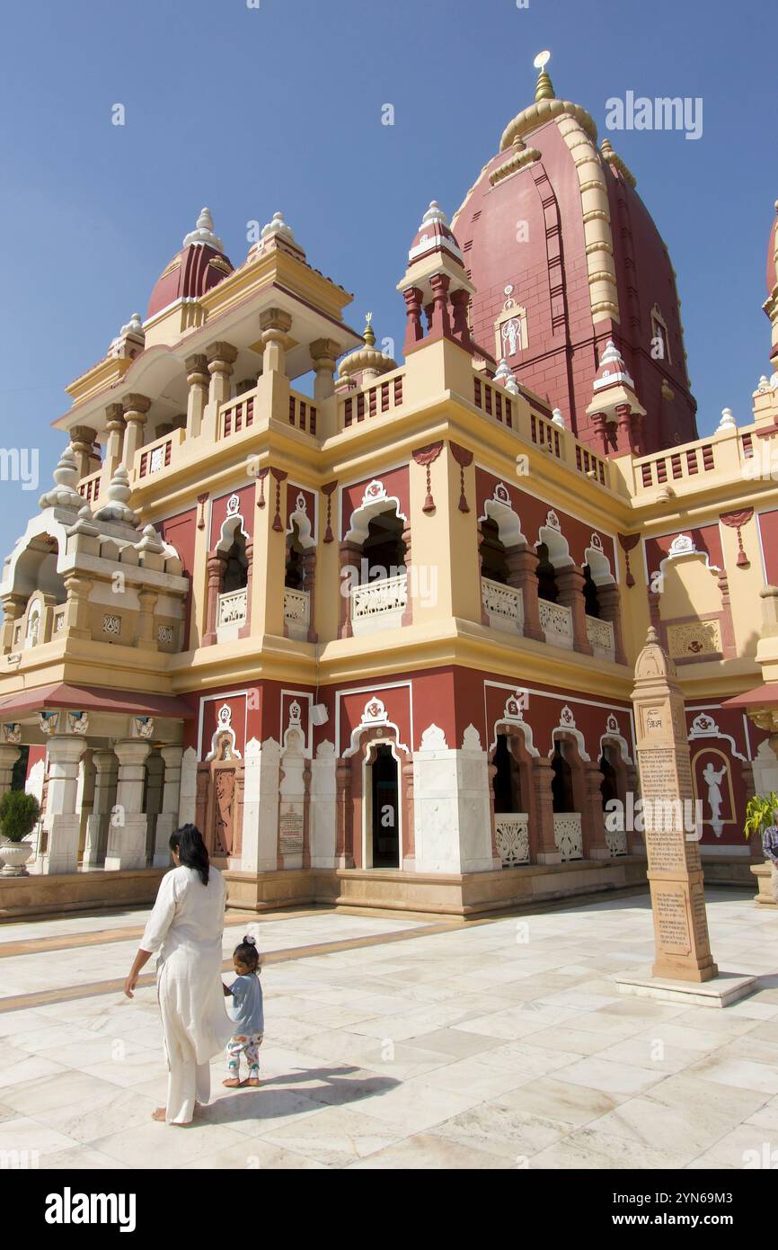 Woman and child walking barefoot outside Hindu Laxminarayan Temple in ...
