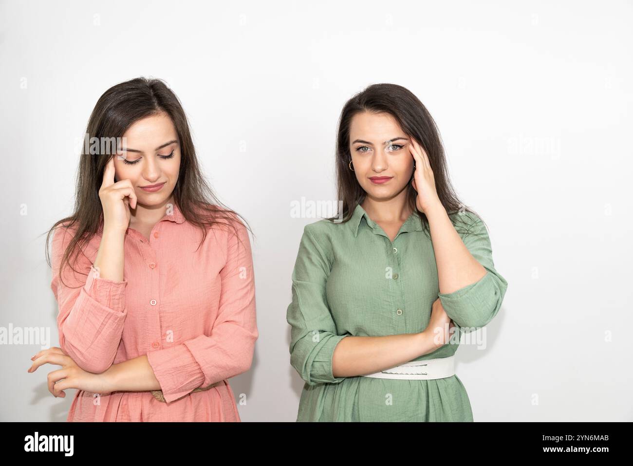 Two Caucasian twin models posing together and thoughtful on white ...