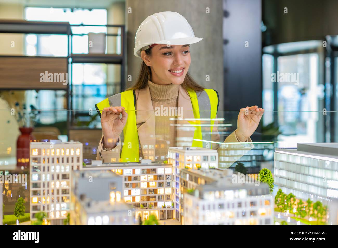 Confident young female architect in hardhat and reflective vest ...