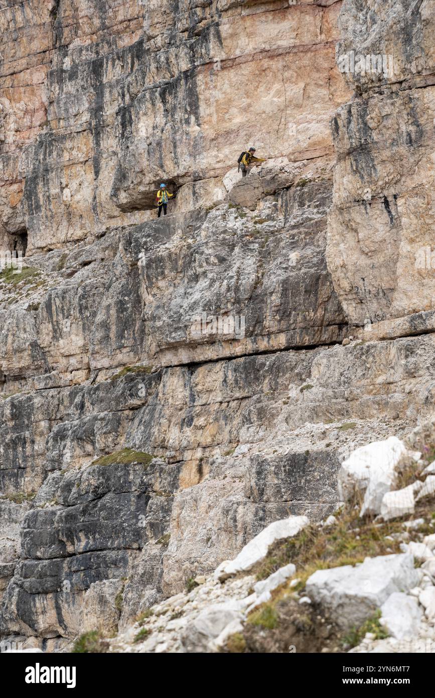 Two people climbing on an old narrow war trail near the Drei Zinnen ...