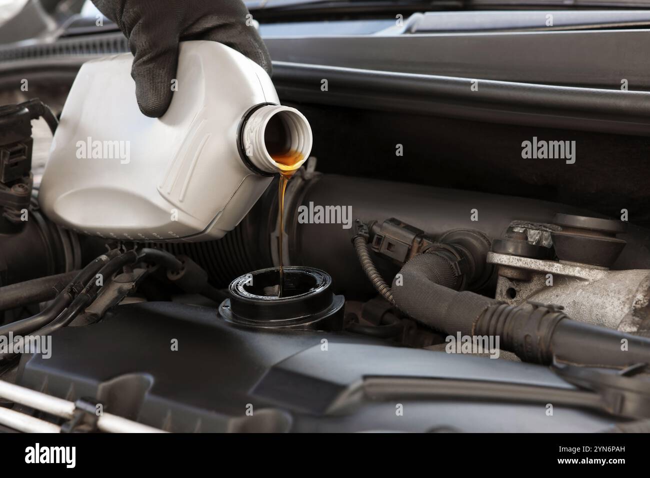 Man pouring motor oil into car engine, closeup Stock Photo - Alamy