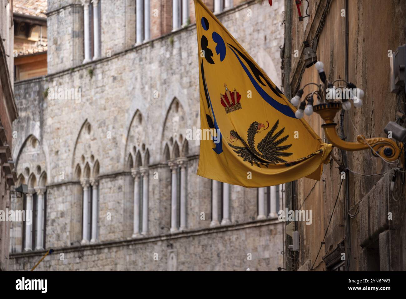 Contrade flags of the Aquila-Eagle district hanging in a street of ...