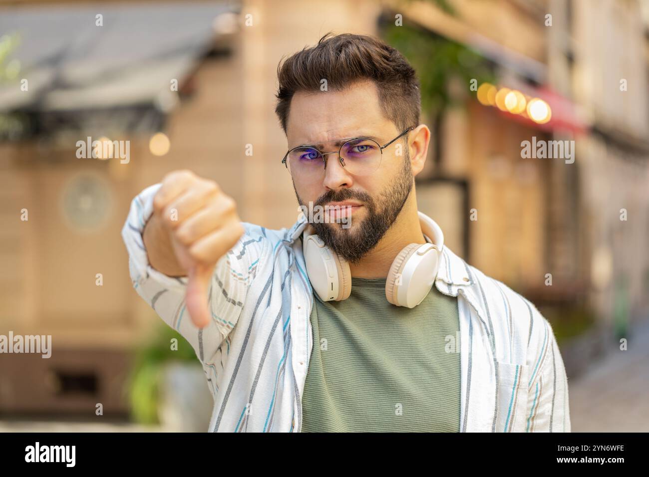 Dislike. Upset Caucasian young man showing thumbs down sign gesture ...