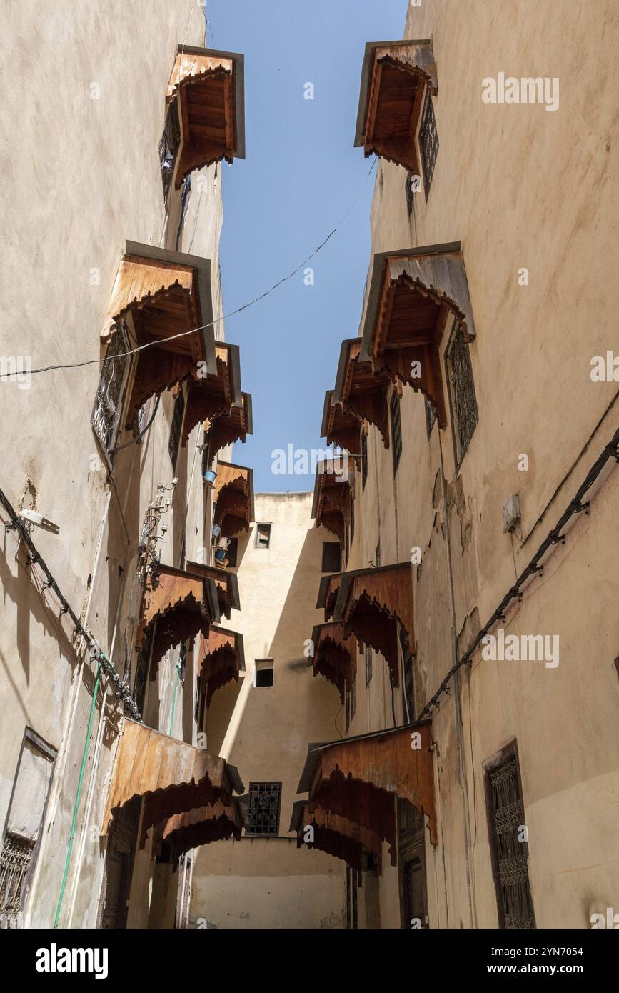 Many wooden window awnings at two residential buildings in Fes, seen ...