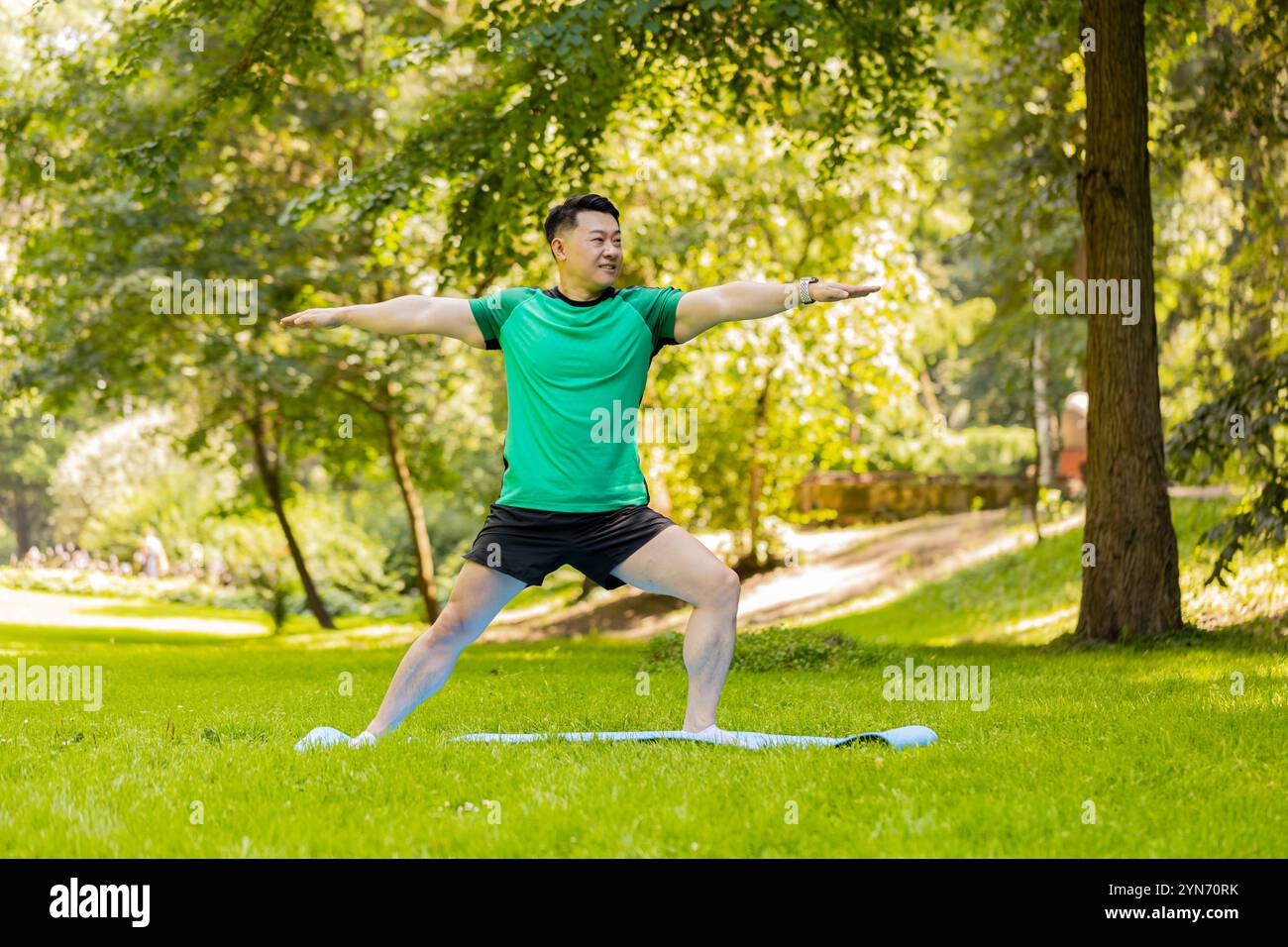 Young sportsman performs gymnastics on mat in urban city park. Sporty ...