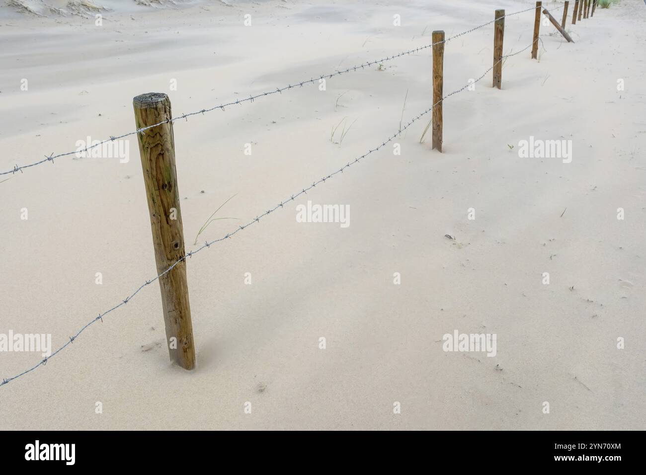 Barbed wire fence on the sandy beach Stock Photo - Alamy