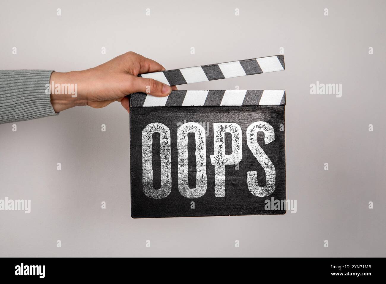 OOPS. Hand holding movie clapper Stock Photo - Alamy