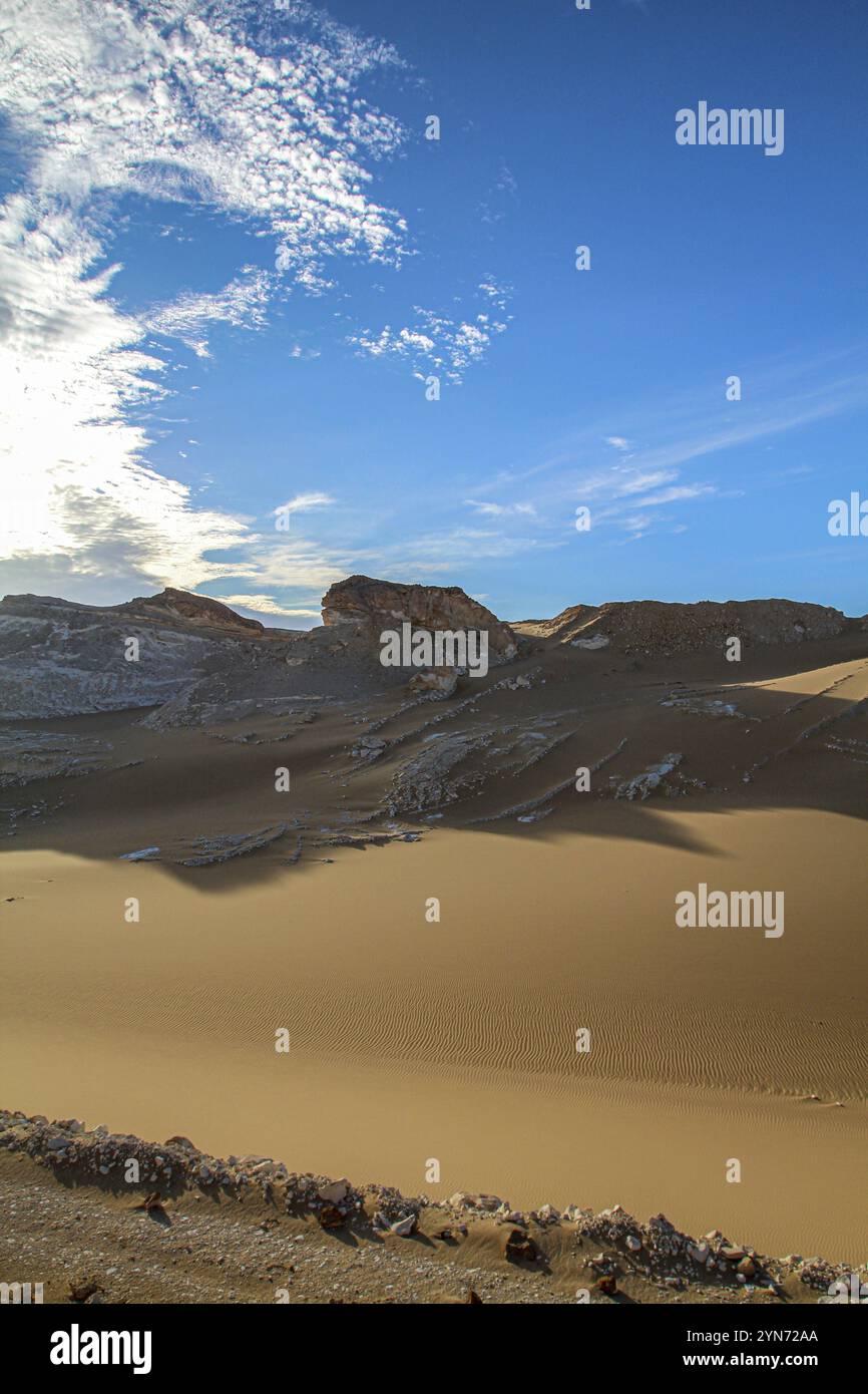 Late afternoon sun casting shadows on rocks in the Libyan desert white ...