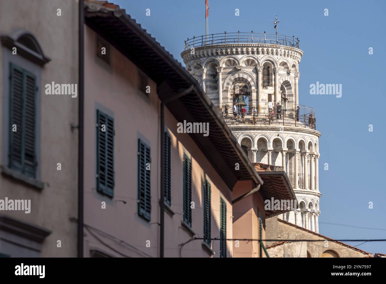 Famous leaning tower of Pisa, residential houses in front, Italy ...