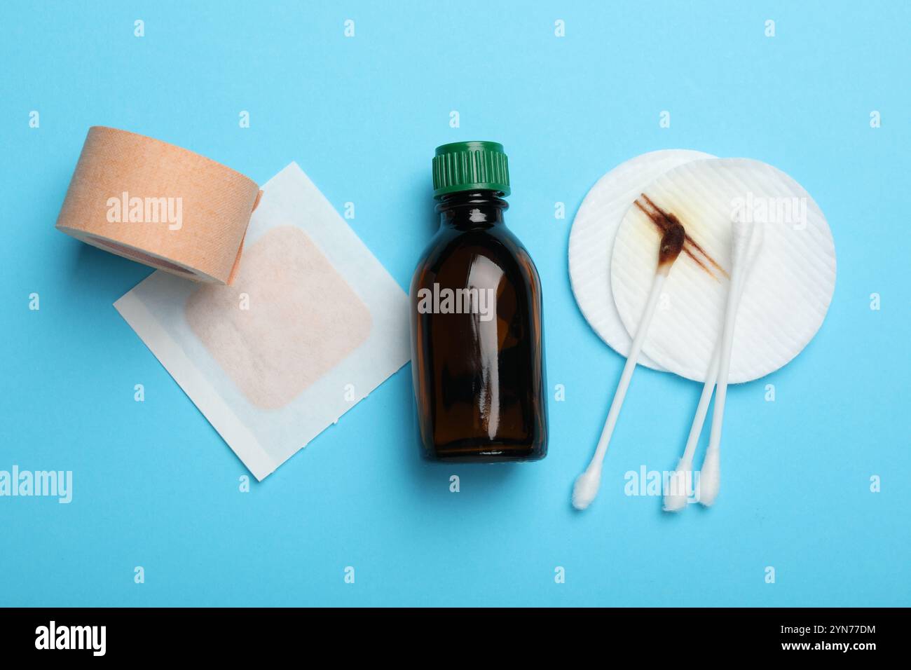 Topical iodine and other first aid kit components on light blue ...