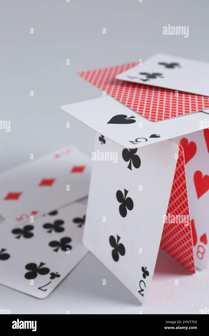 Collapsed house of playing cards on light grey background, closeup ...