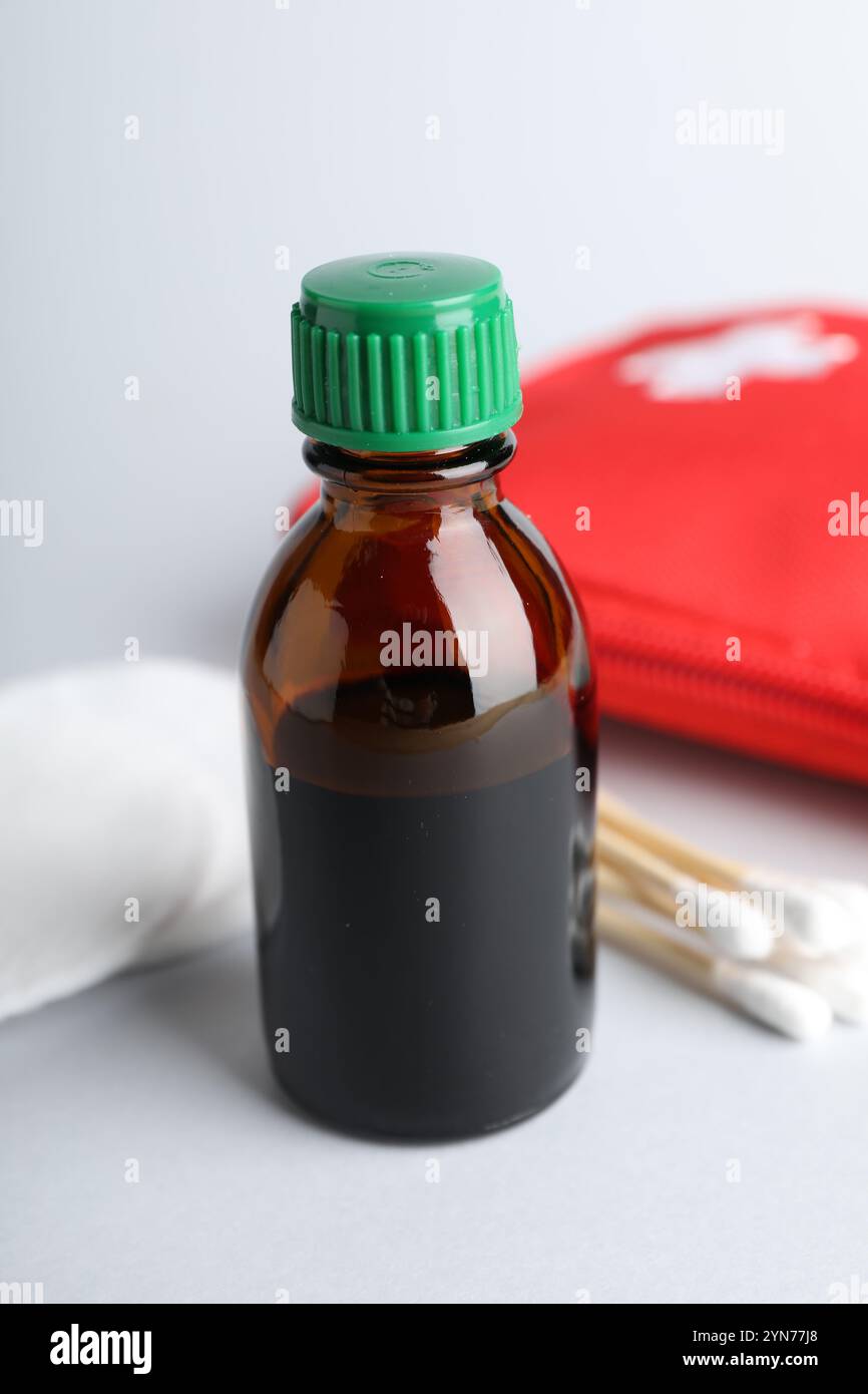 Topical iodine and other first aid kit components on light background ...