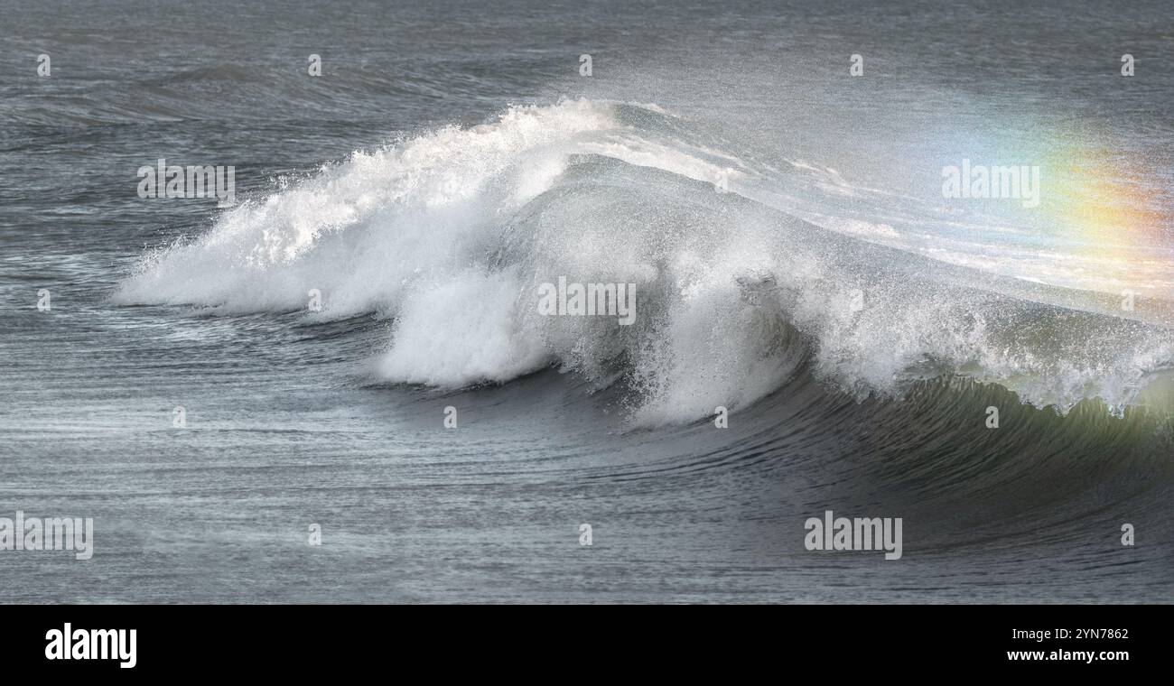 A breaking wave creating a rainbow, full frame, long size Stock Photo ...