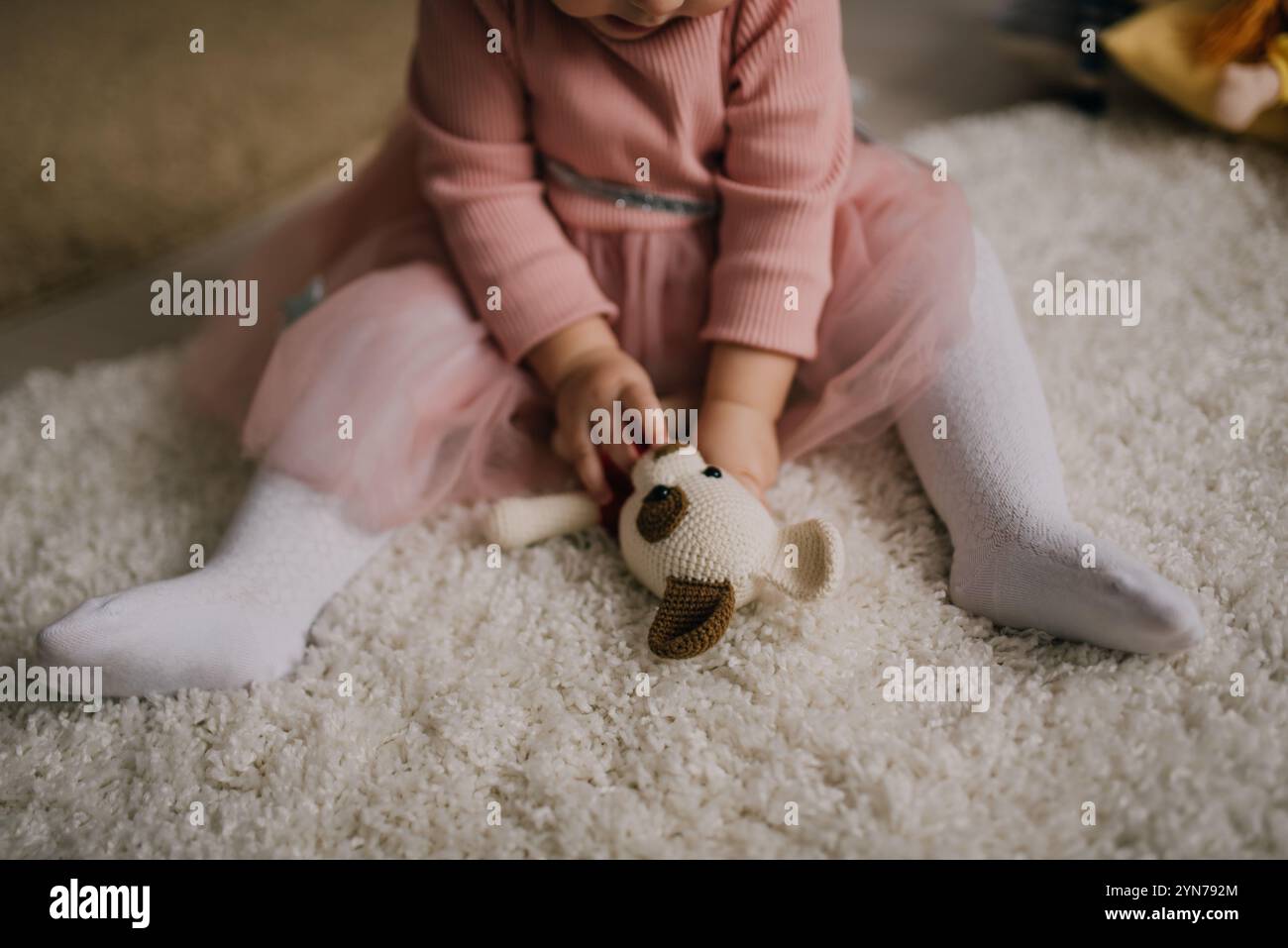 Child holding a plush toy. The photo captures a heartwarming scene of a ...