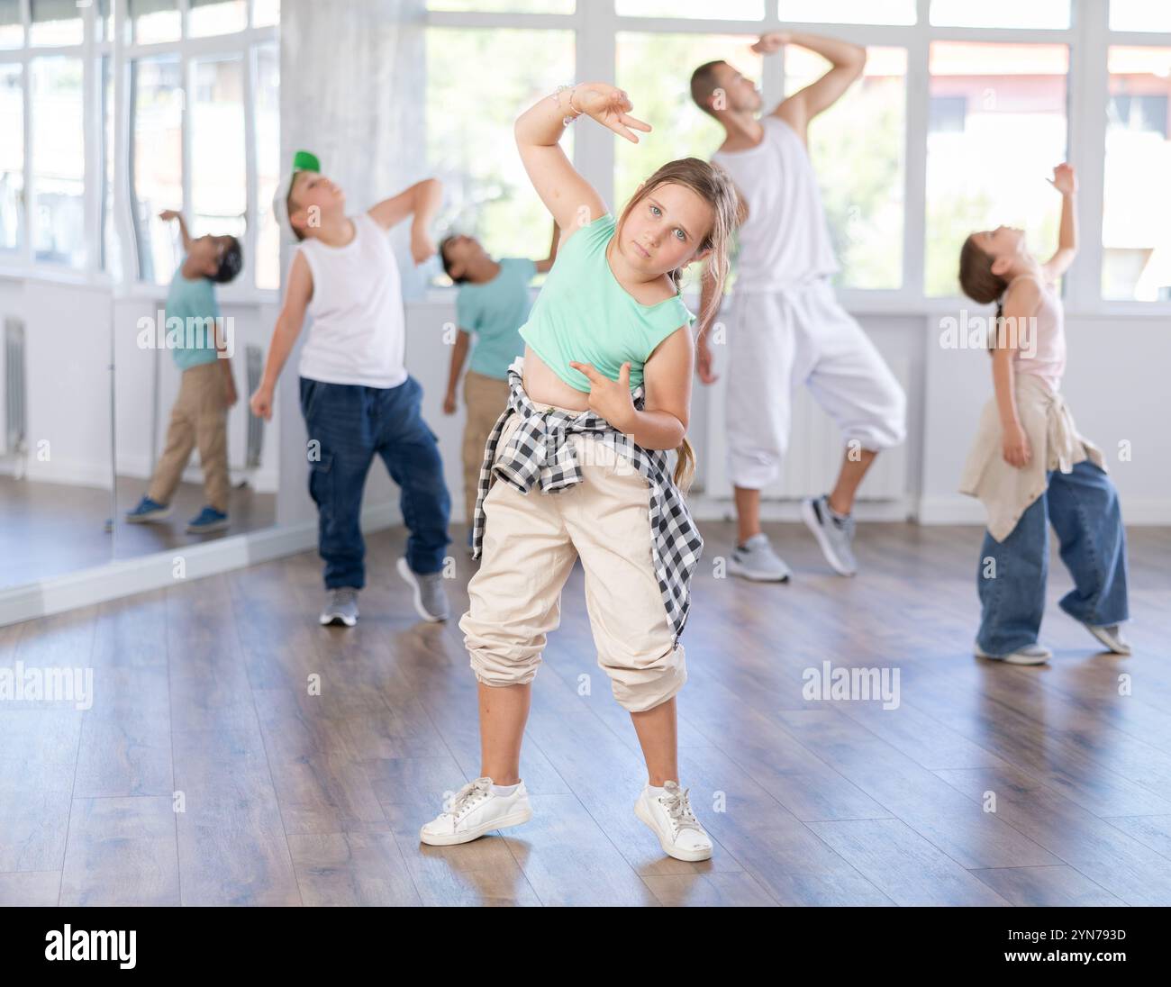 Children practicing hip-hop dance in training hall during group dancing ...