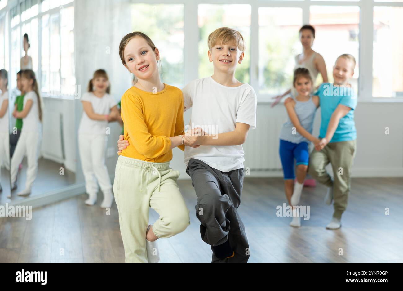 Preteen children learn to dance tango under guidance of a teacher in ...