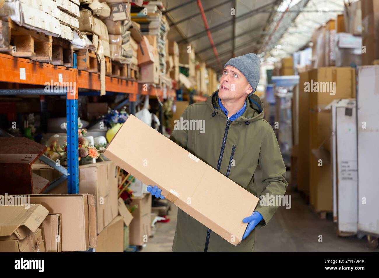 Warehouse worker carrying pasteboard box Stock Photo - Alamy