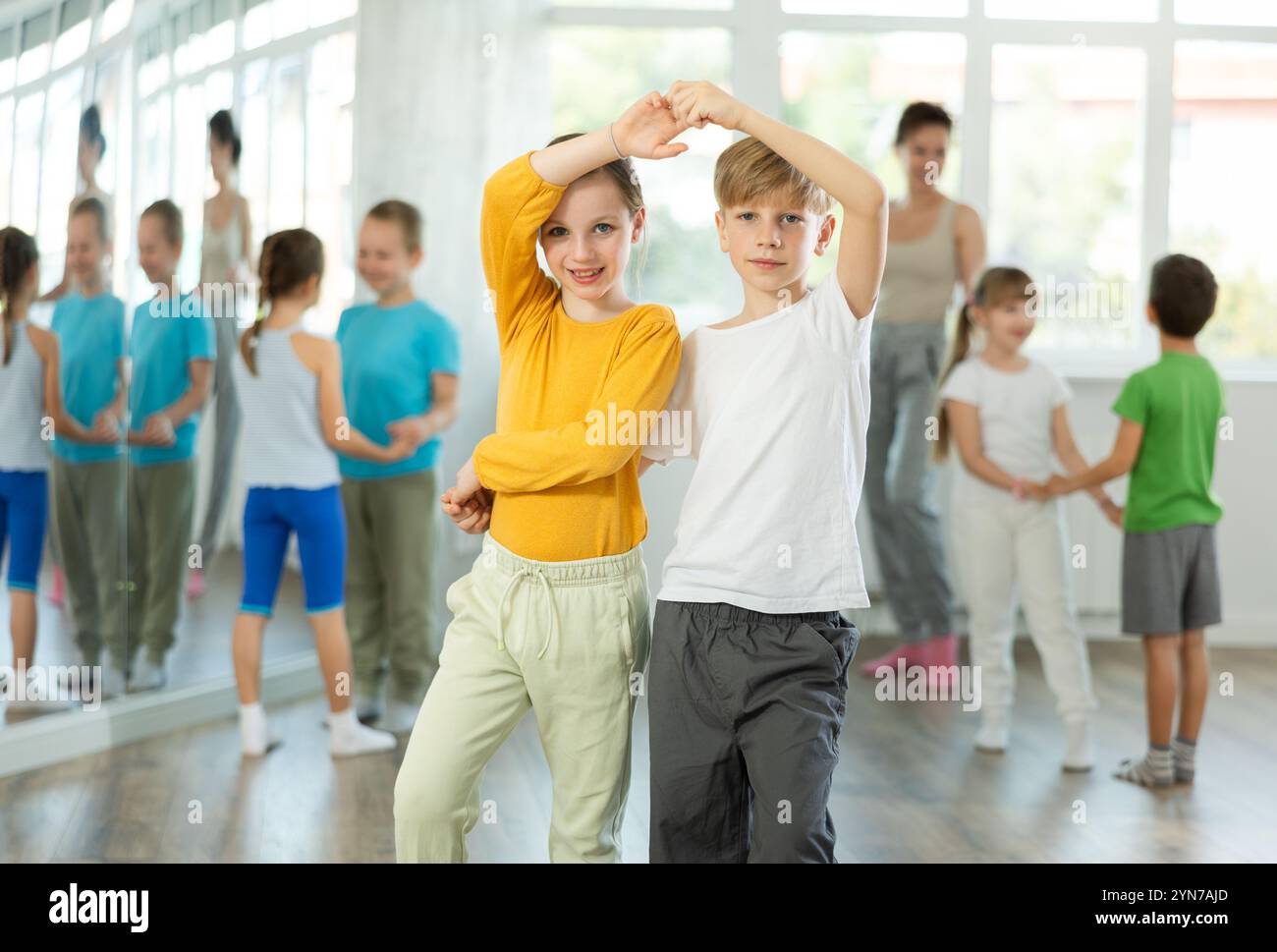 Happy preteen children practicing ballroom dances in pairs in training ...