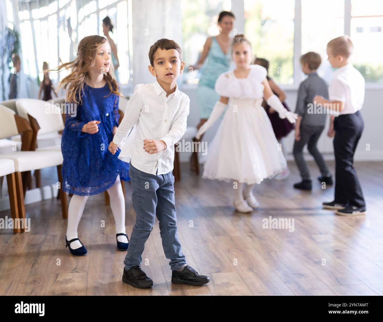 Expressive preteen boy performing twist dance during children party ...