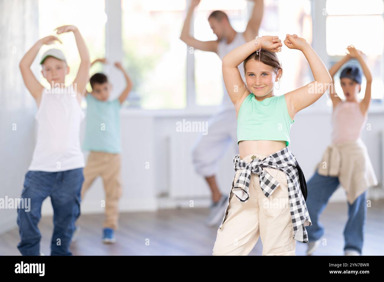 Tween girl dancer rehearsing krump dance at group workout Stock Photo ...